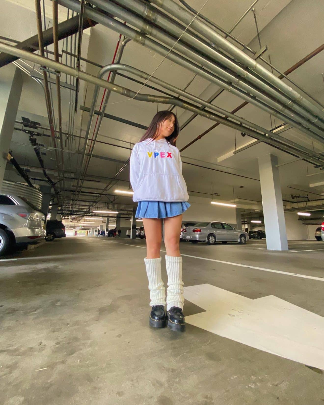 Jade Hallyday en mini jupe plissée et guêtres : découvrez son look tendance